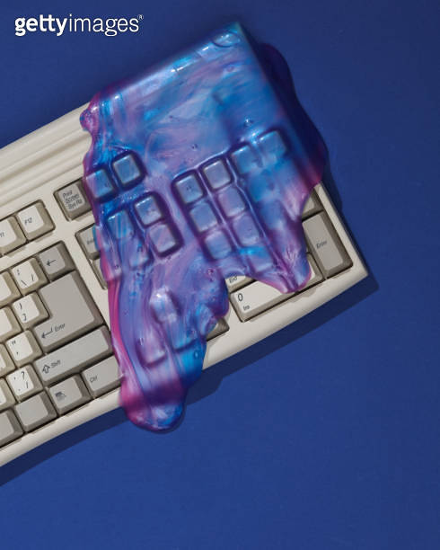 Creative retro layout, Old keyboard with space color slime on dark blue ...