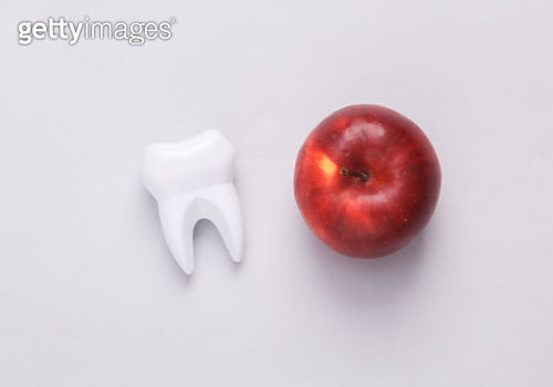 The concept of healthy teeth. Apple and tooth model on gray background ...