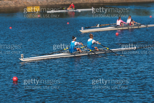 Group of rowing team female girl athletes sculling during competition ...