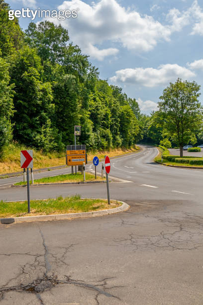 Various traffic signs on an empty country road: no entry, caution ...