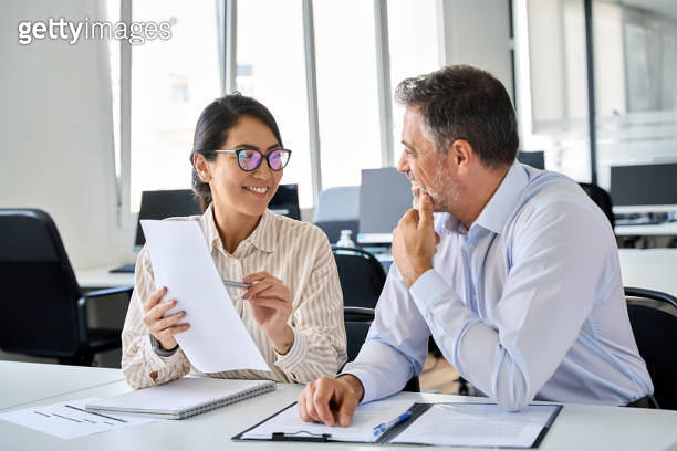 Two happy diverse managers working in office discussing financial ...