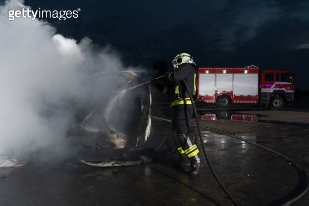 Firefighters using water fire extinguisher to fighting with the fire ...