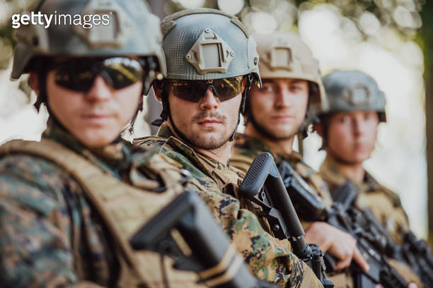 Soldier fighters standing together with guns. Group portrait of US army ...