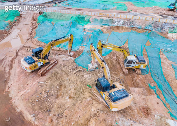 excavator on caterpillars in the foundation pit during the construction ...