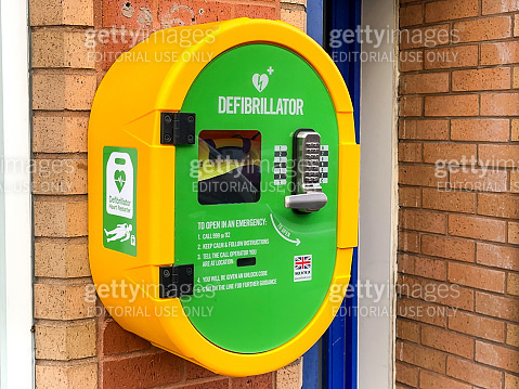 Emergency defibrillator in a case on the wall of a building in a town ...