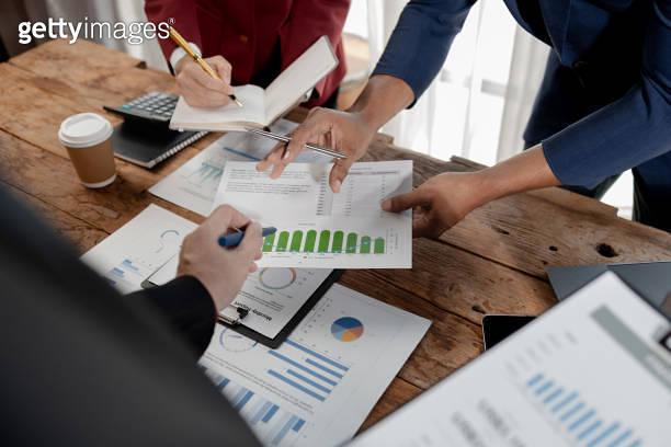 Group of businessmen working together to calculate income, They are ...