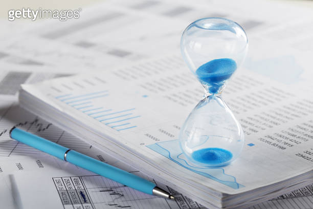 Best time for investment. Hourglass, financial charts and calculator ...