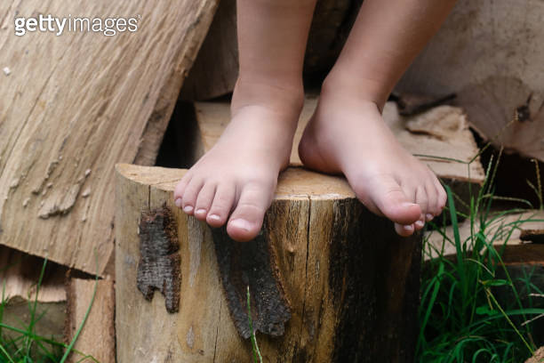 Child feet on wood log, barefoot little girl on tree trunk, countryside ...