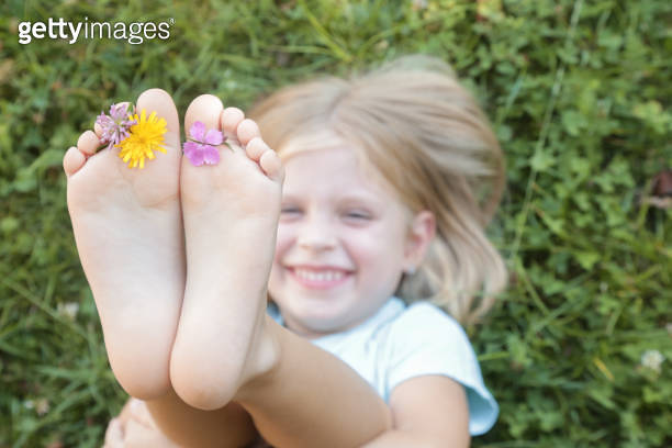 Child feet on green grass, barefoot little girl on meadow, countryside ...