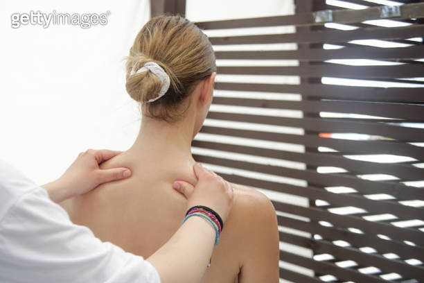Shoulder massage. Young Caucasian woman enjoing soft shooting partial ...