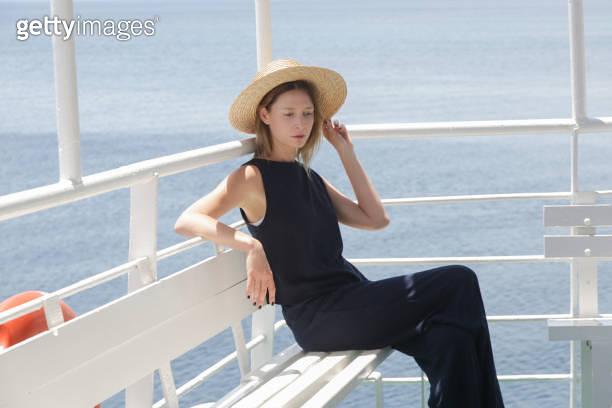 Stylish tourist woman in blue linen outfit and straw hat travelling on ...
