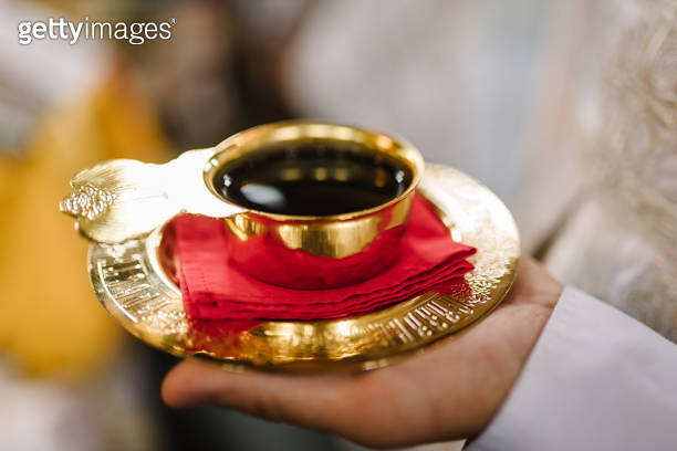 Wedding bowl in the church in the priest's hand. Golden cup of blood. A ...