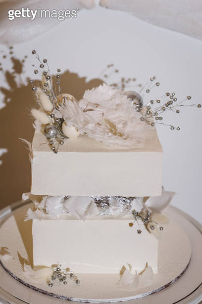 Details trendy cake with figure newborn, wings angel and silver decor. Celebration baptism ...