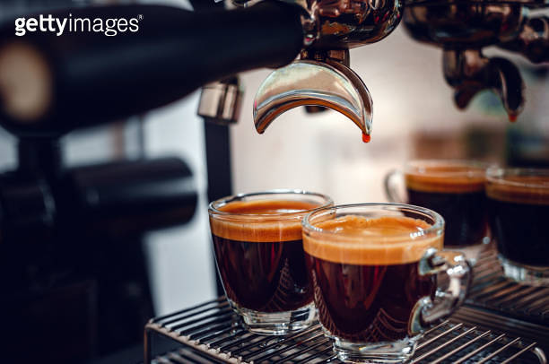 Professional espresso machine while preparing two espressos shot in a coffee shop. Close-up of ...