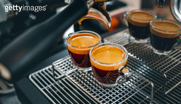 Professional espresso machine while preparing two espressos shot in a coffee shop. Close-up of ...