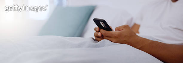 Typing, bed and hands of a man with a phone for social media, communication and chat. Contact ...