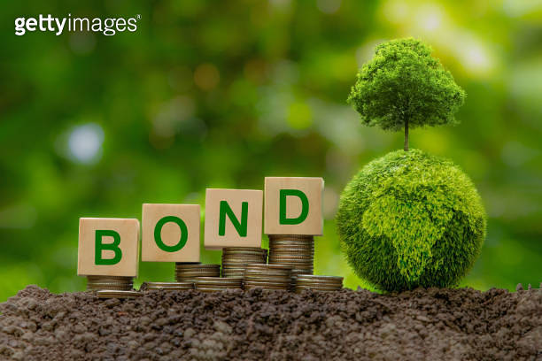 Green bonds concept. Words BOND on a wood block place on coin stack and ...