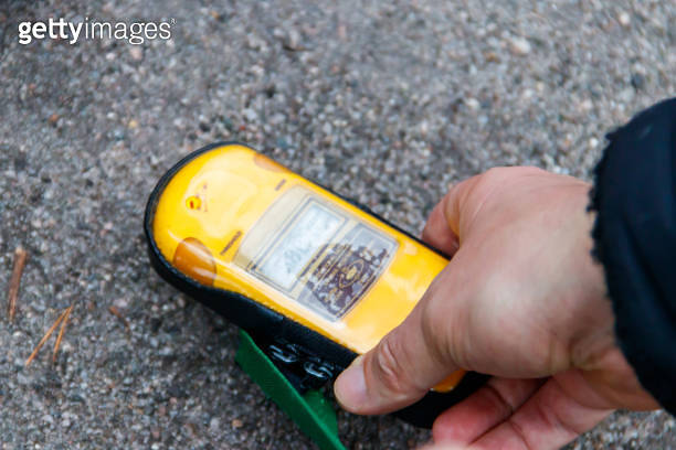 Male hand holding a dosimeter. Measurement of radiation levels by the ...