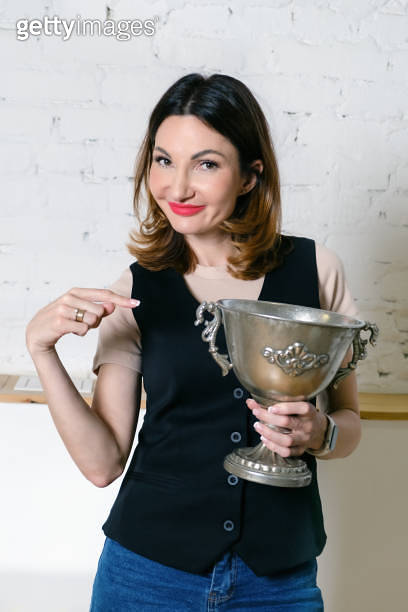 Beautiful woman holds a chalice in her hands and smiles (1542548569 ...