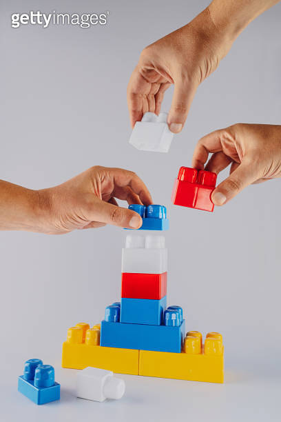 Hands making towers from colored blocks 이미지 (1771352071) - 게티이미지뱅크