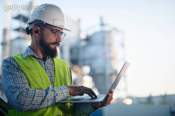 Hard working engineer on the power station with laptop. (1606326363 ...