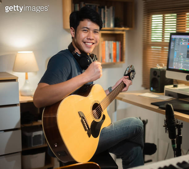 Group of Asian men making music at home studio. He is happy that the ...
