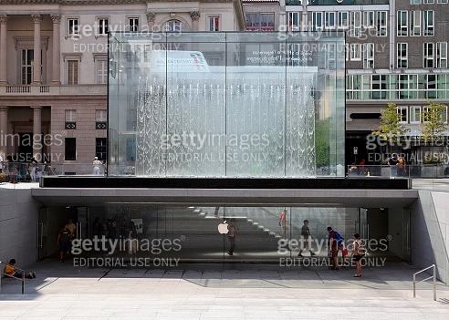 Glass facade of the entrance with a fountain to the Apple company store ...