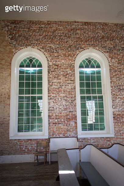 Tall arched windows with shutters in old abandoned church building ...