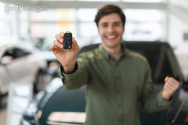 Handsome young guy showing new car key at camera, making YES gesture ...