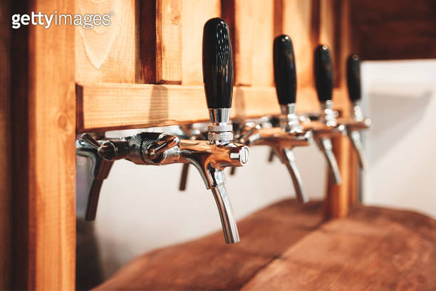 Beer bar counter with a row of taps for dispensing beer, wooden ...