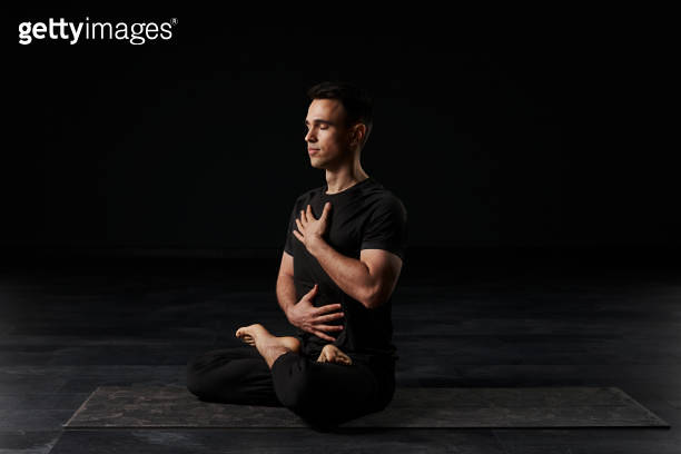 With poise and grace, a striking young man in black attire immerses ...