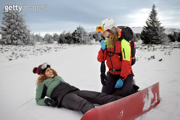 Female rescue worker helping young woman that injured herself during ...