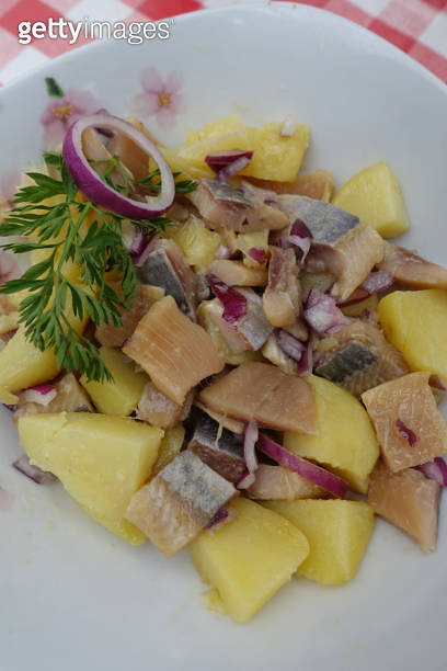 Salad of smoked herring and boiled potatoes in portions with preserved ...