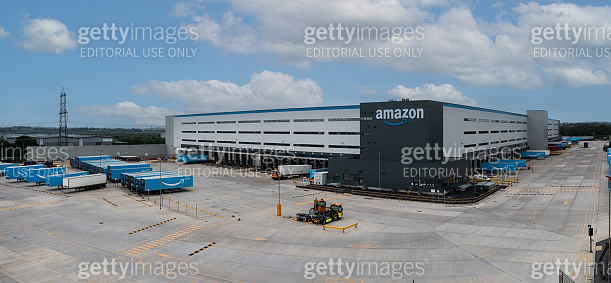 Aerial view of a large Amazon Prime distribution warehouse with trailers and loading bay 이미지 ...