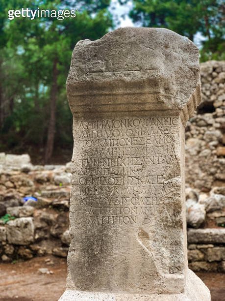 Ancient stone column with Greek inscriptions and hieroglyphs. Antique ...