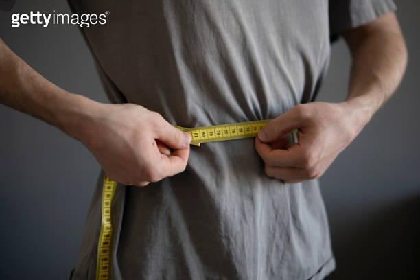 Man Measures Waist Circumference With Yellow Tape During Fitness Check ...