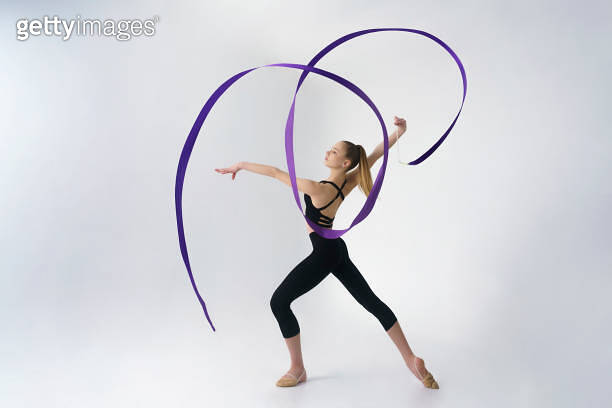 young gymnast in a photo studio shows the elements of exercises with a ...