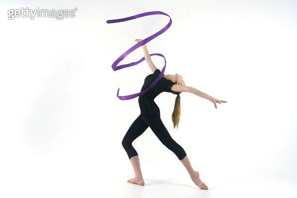 young gymnast in a photo studio shows the elements of exercises with a ...