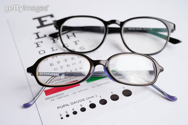 Glasses on eye exam chart to test eyesight accuracy of reading ...