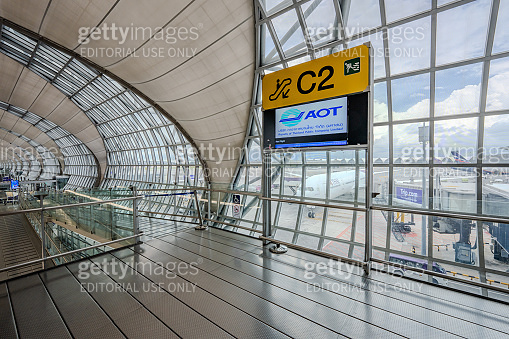 Suvarnabhumi Airport Gate C2: Passengers directed by an escalator to ...