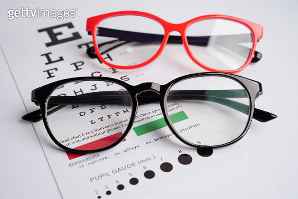 Glasses on eye exam chart to test eyesight accuracy of reading ...