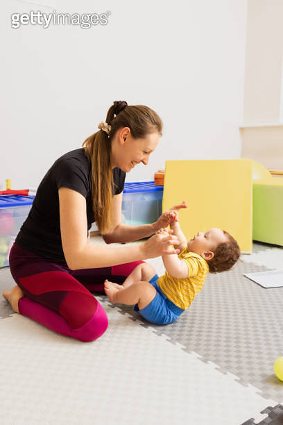 Hypotonia in babies, muscle weakness. Testing of toddler reflexes with ...