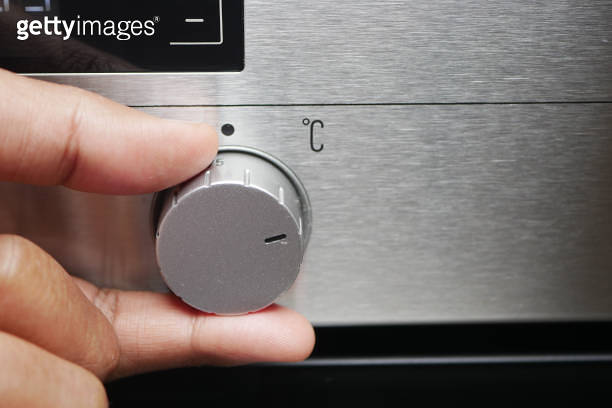 Close up of men hand setting temperature control on oven. 이미지 ...