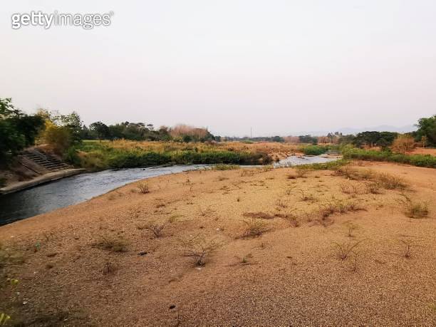 a photography of a river running through a dry grass covered field. 이미지 ...
