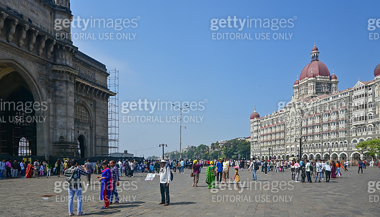 Tourist visit the most famous attractions of Mumbai. Taj Mahal Palace Hotel and Gateway of India ...