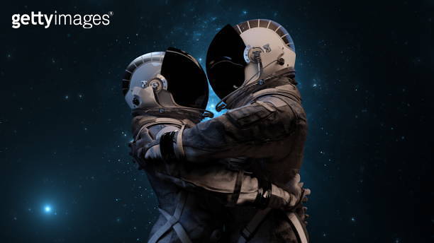 Two astronauts couple in space suits embracing against a backdrop of ...