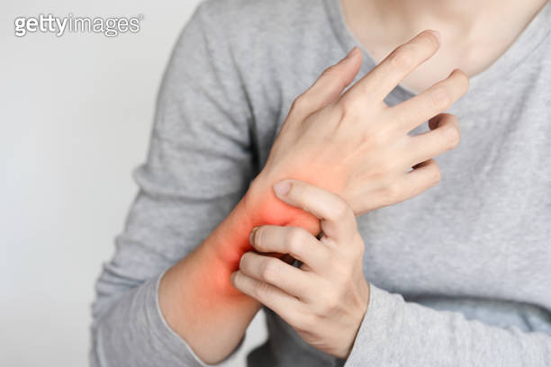 Person experiencing wrist pain, inflammation shown with red area on the ...