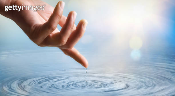 Hand with drop falling from finger forming waves in water 이미지 ...