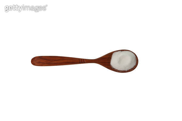Food additive E316 in wooden spoon on white background. White powder ...