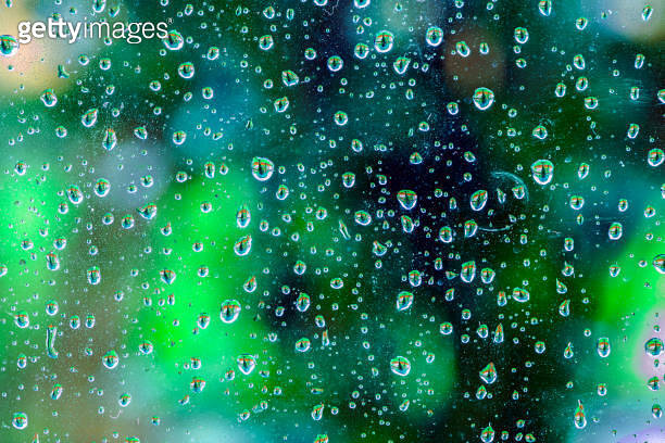 Water drops on a green glass - refreshing detail of bright water drops ...